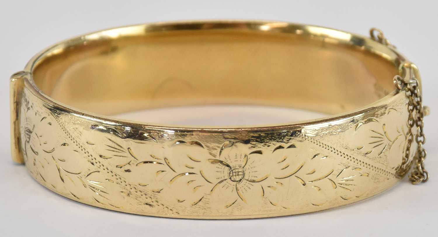 Lot 1317 - A 9ct gold metal core hinged bangle, the