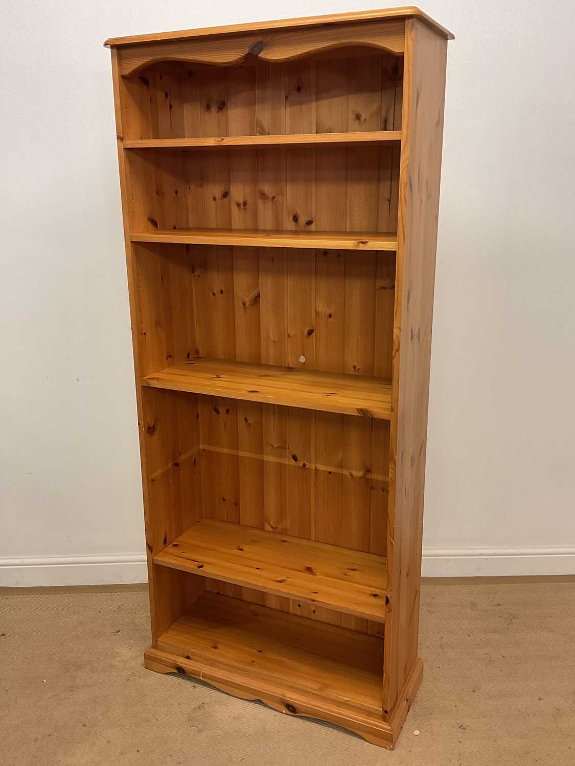 Lot 563 - A pine open bookcase with four shelves,
