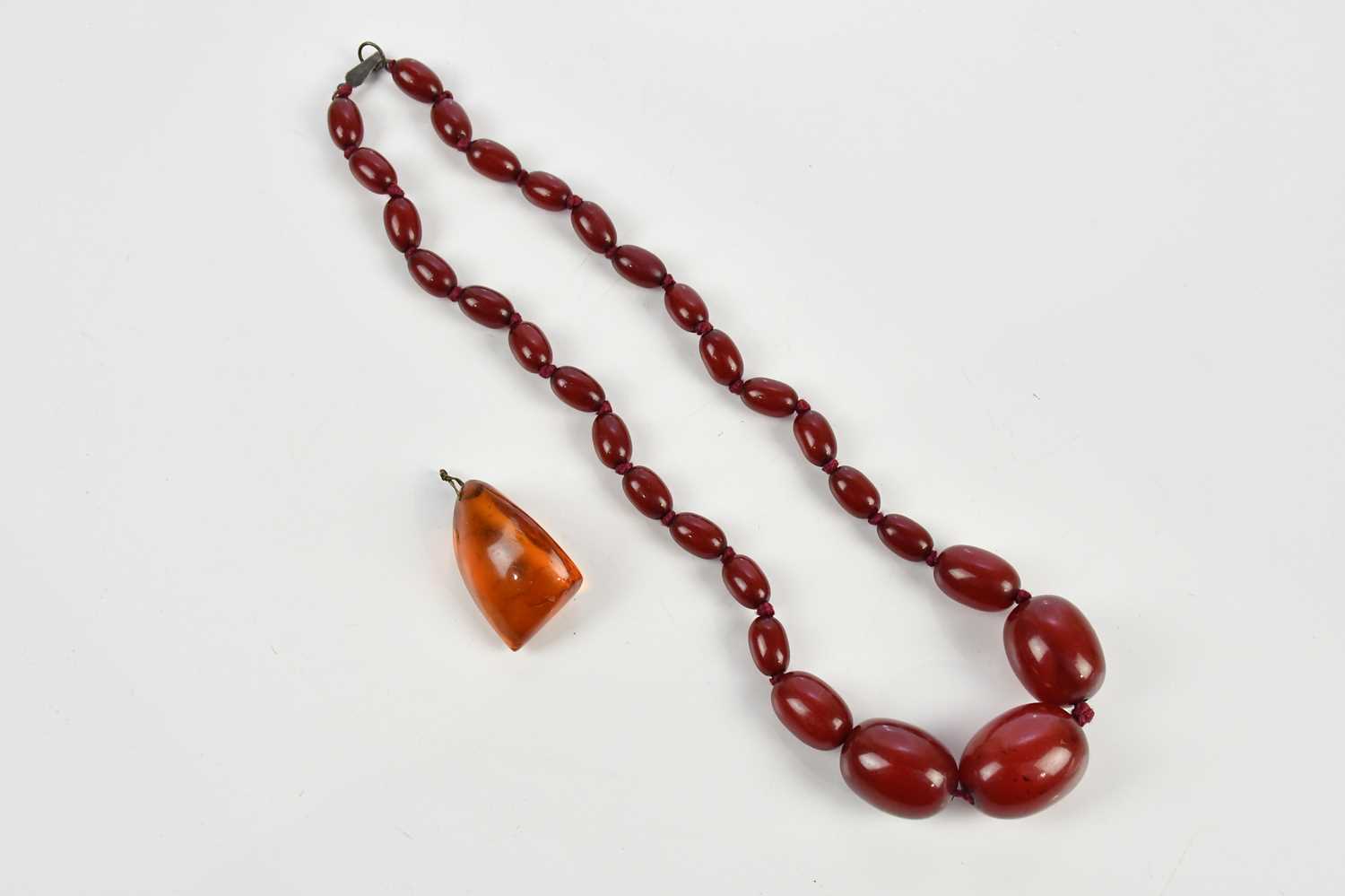 Lot 1627 - A graduated cherry amber coloured necklace