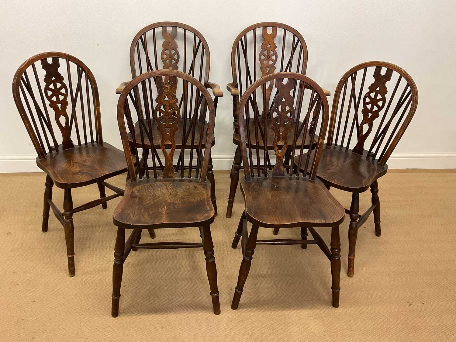 Lot 530 - A set of six beech and oak wheel back chairs,