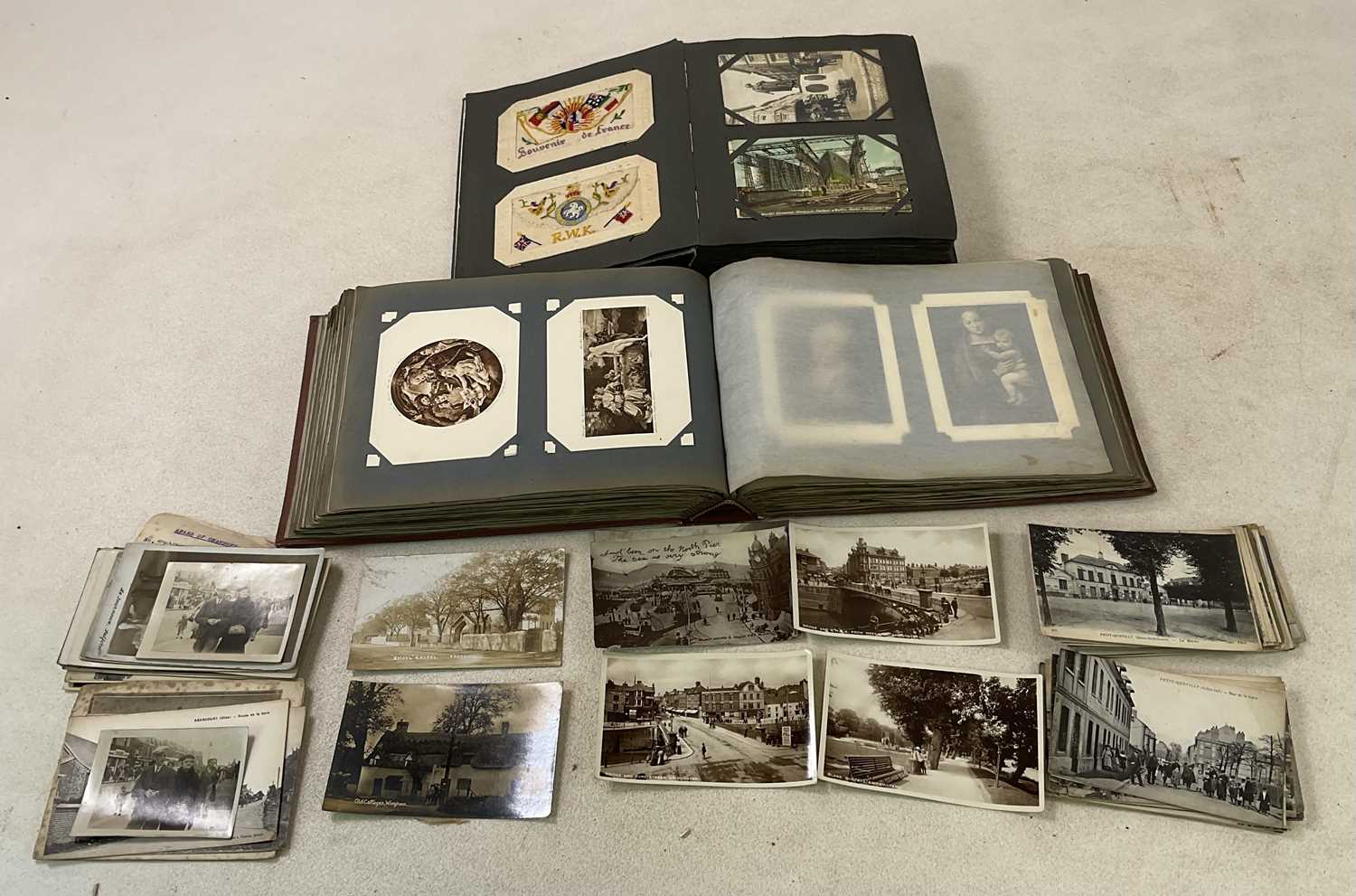 Lot 126 - Two albums of postcards, the first album