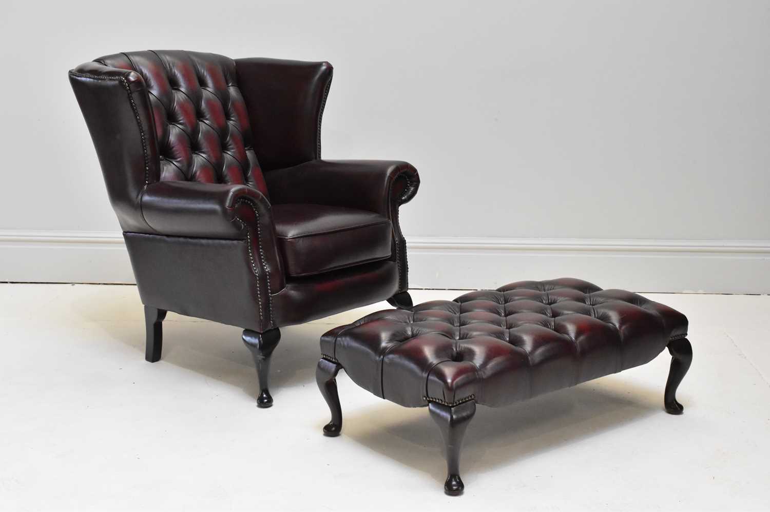 Lot 1096 - A large reproduction wing-back elbow chair,