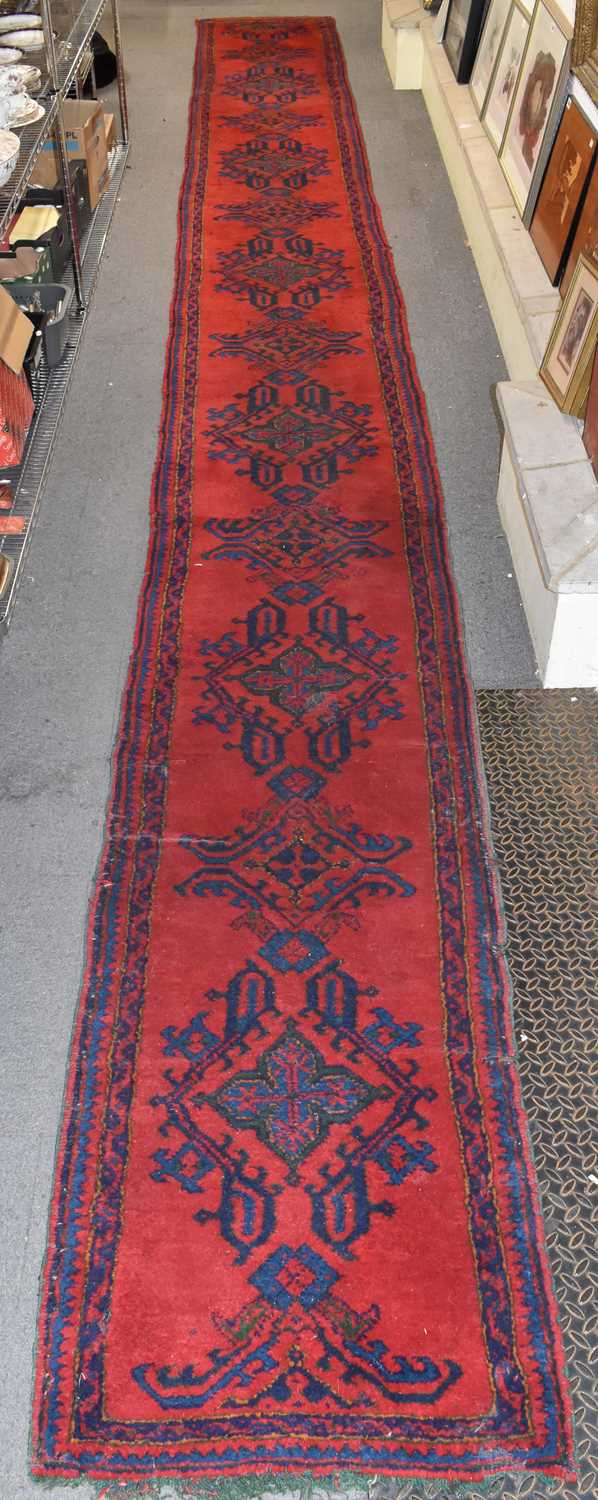 Lot 105 - A red ground runner with border and