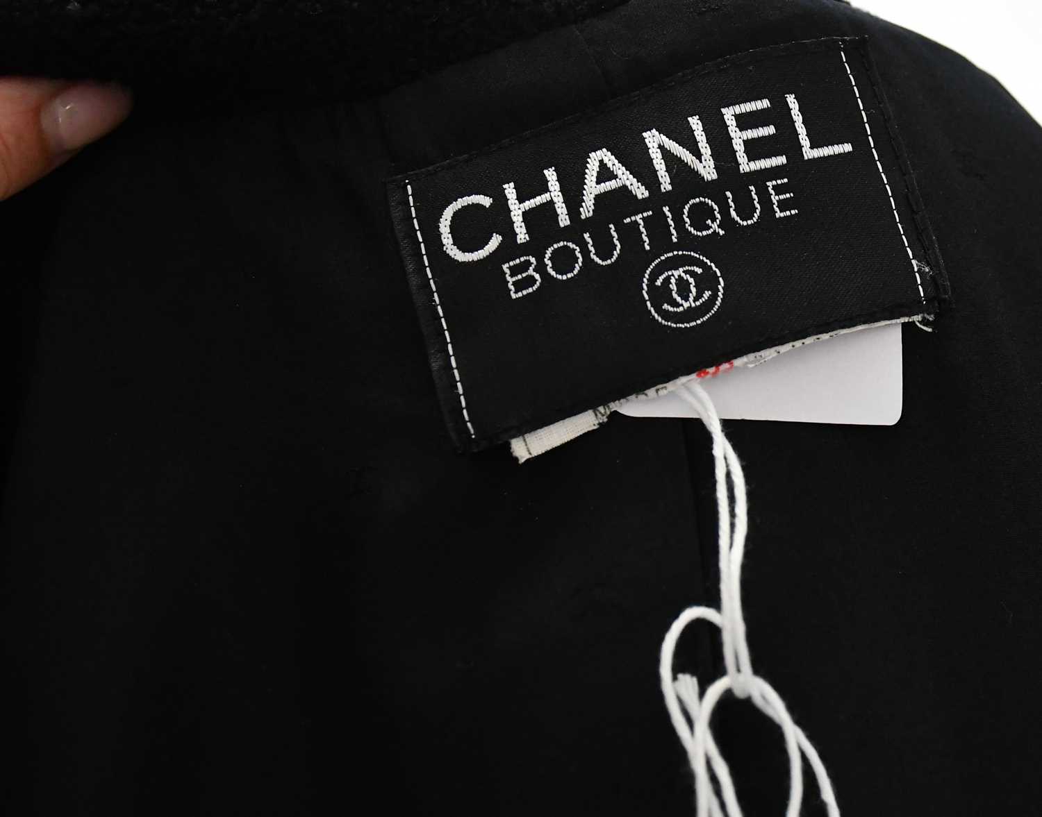 Lot 170 - CHANEL; a black bouclé short jacket with