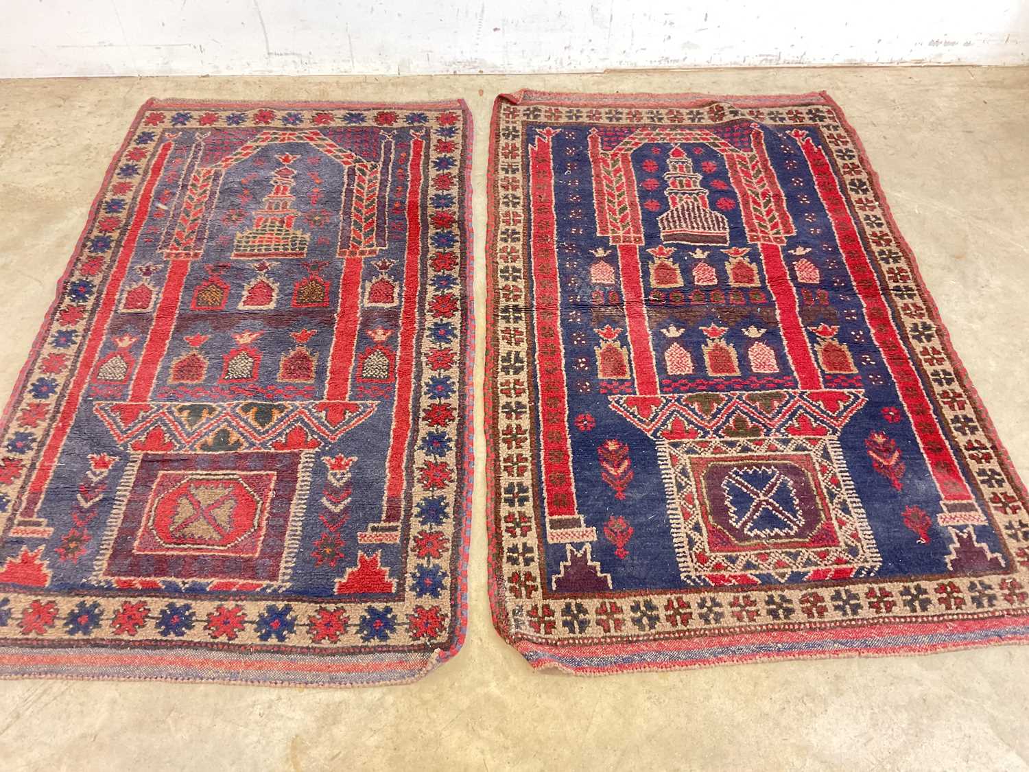 Lot 454 - Two Eastern prayer mats in blues and reds,