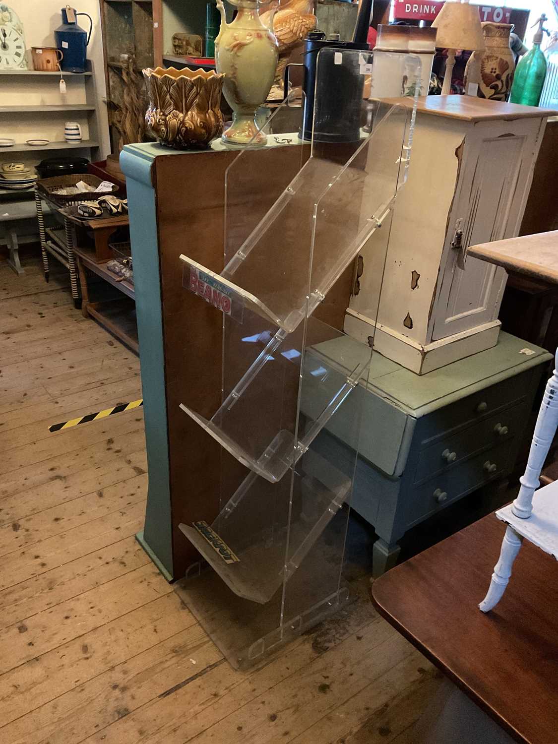 Lot 399 - A perspex three tier magazine display shelf,