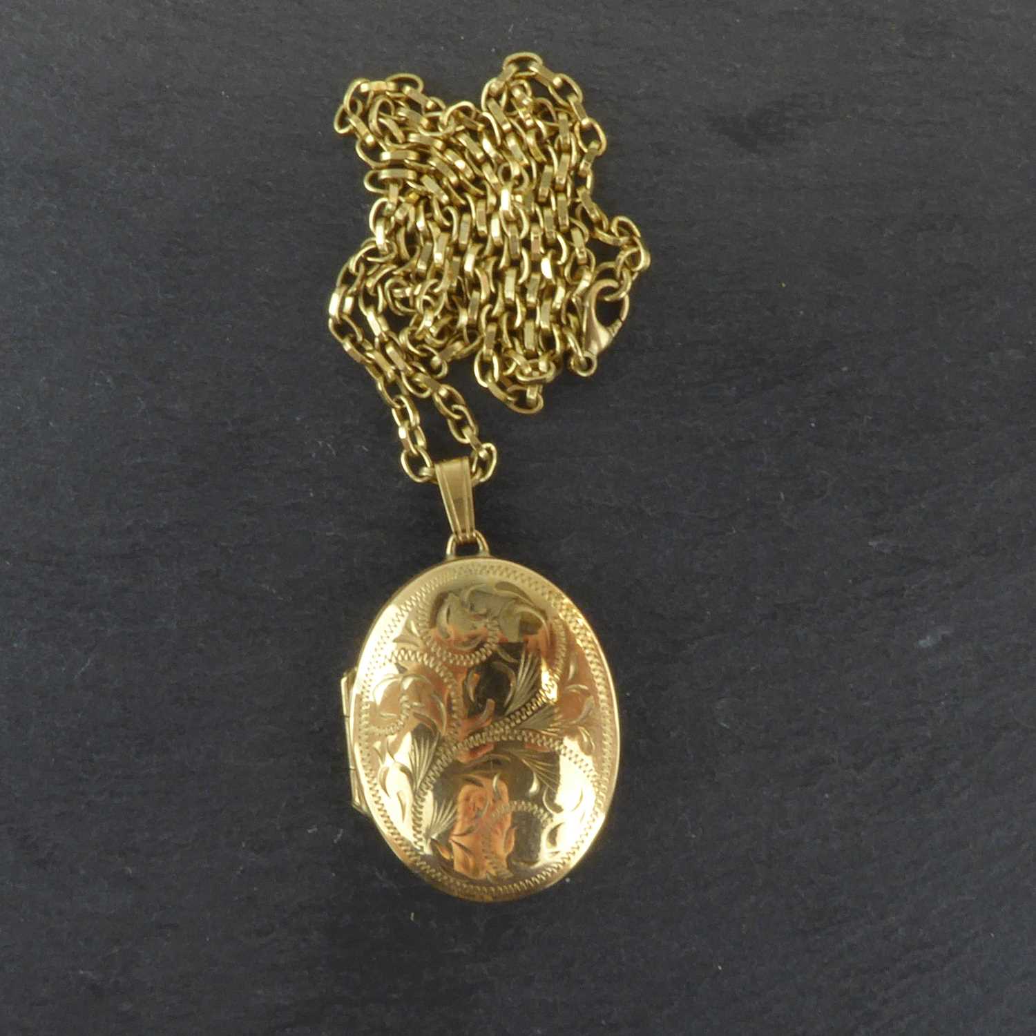 Lot 1230 - A 9ct gold oval double locket with floral