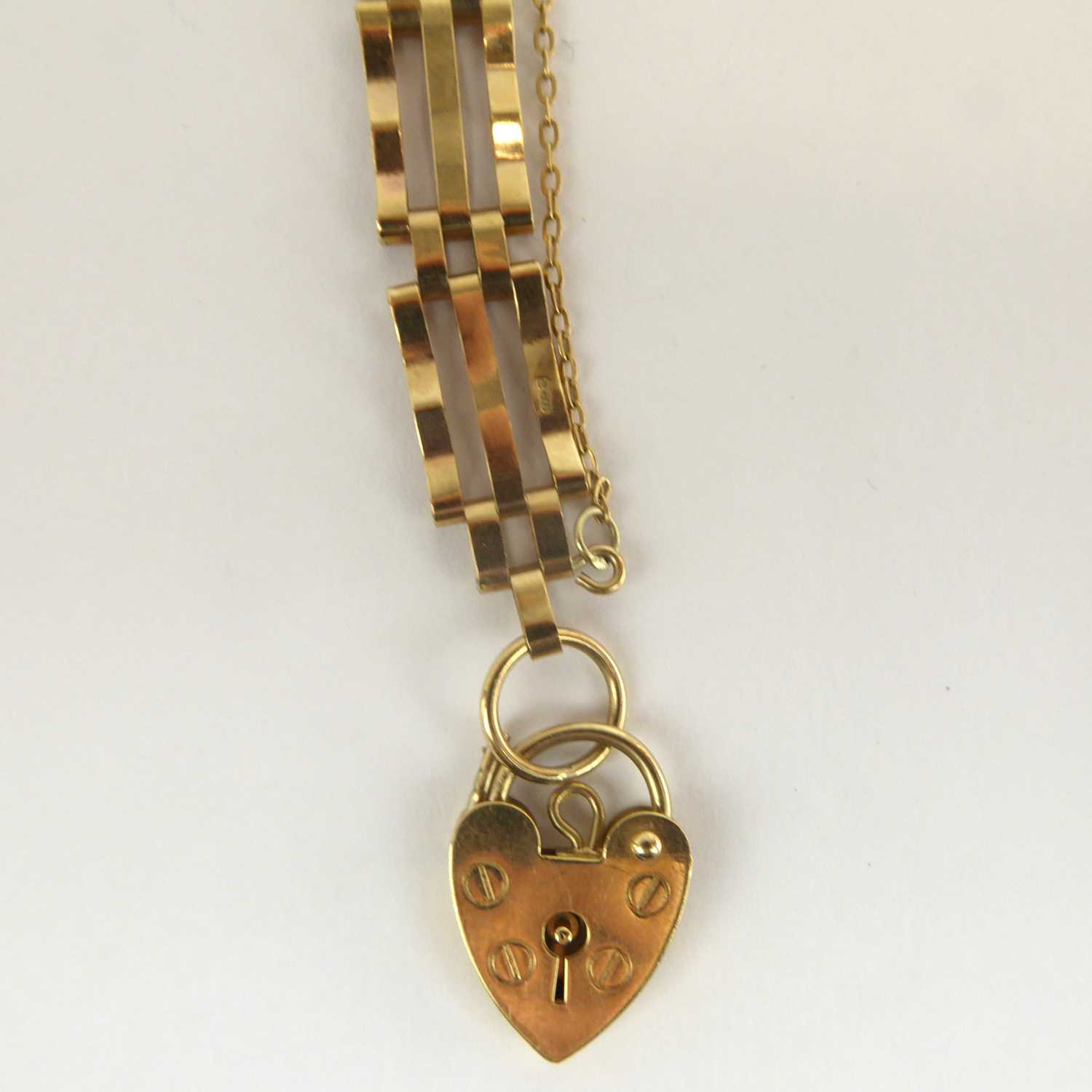 Lot 1045 - A 9ct gold three bar gate bracelet with a