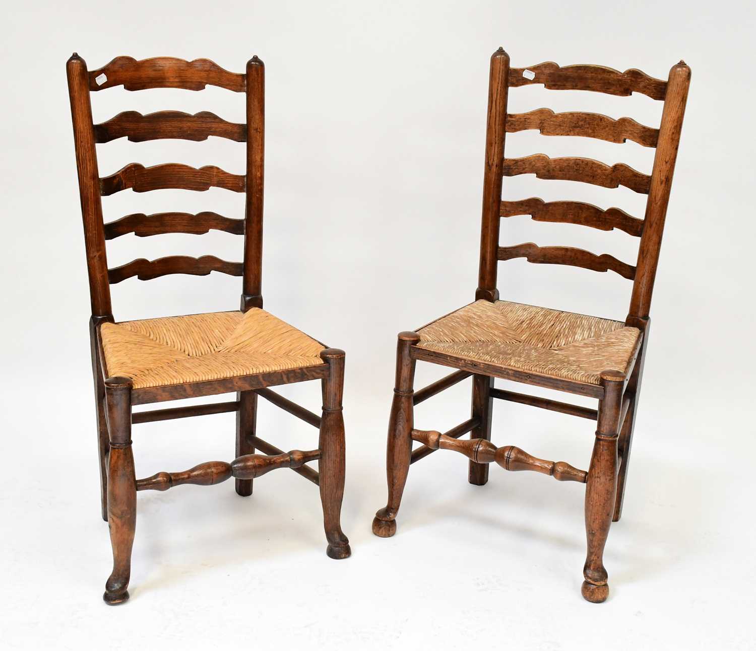 Lot 2 - A harlequin set of seven wavy ladder back rush-