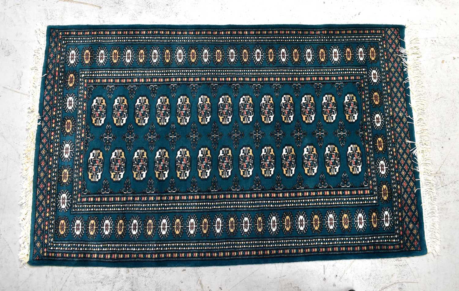 Lot 92 - A red ground Bokhara design rug and a green