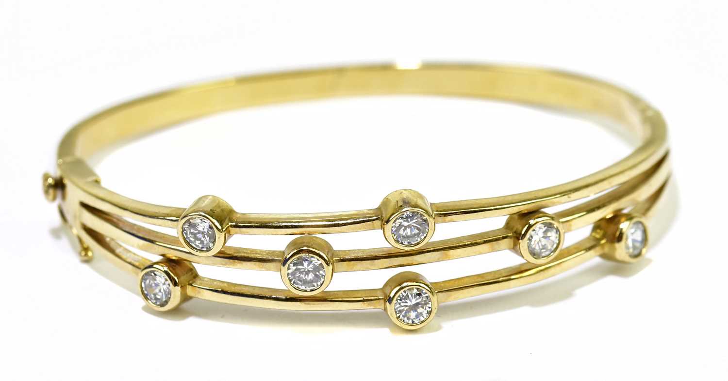 Lot 189 - A yellow metal hinged snap bangle set with