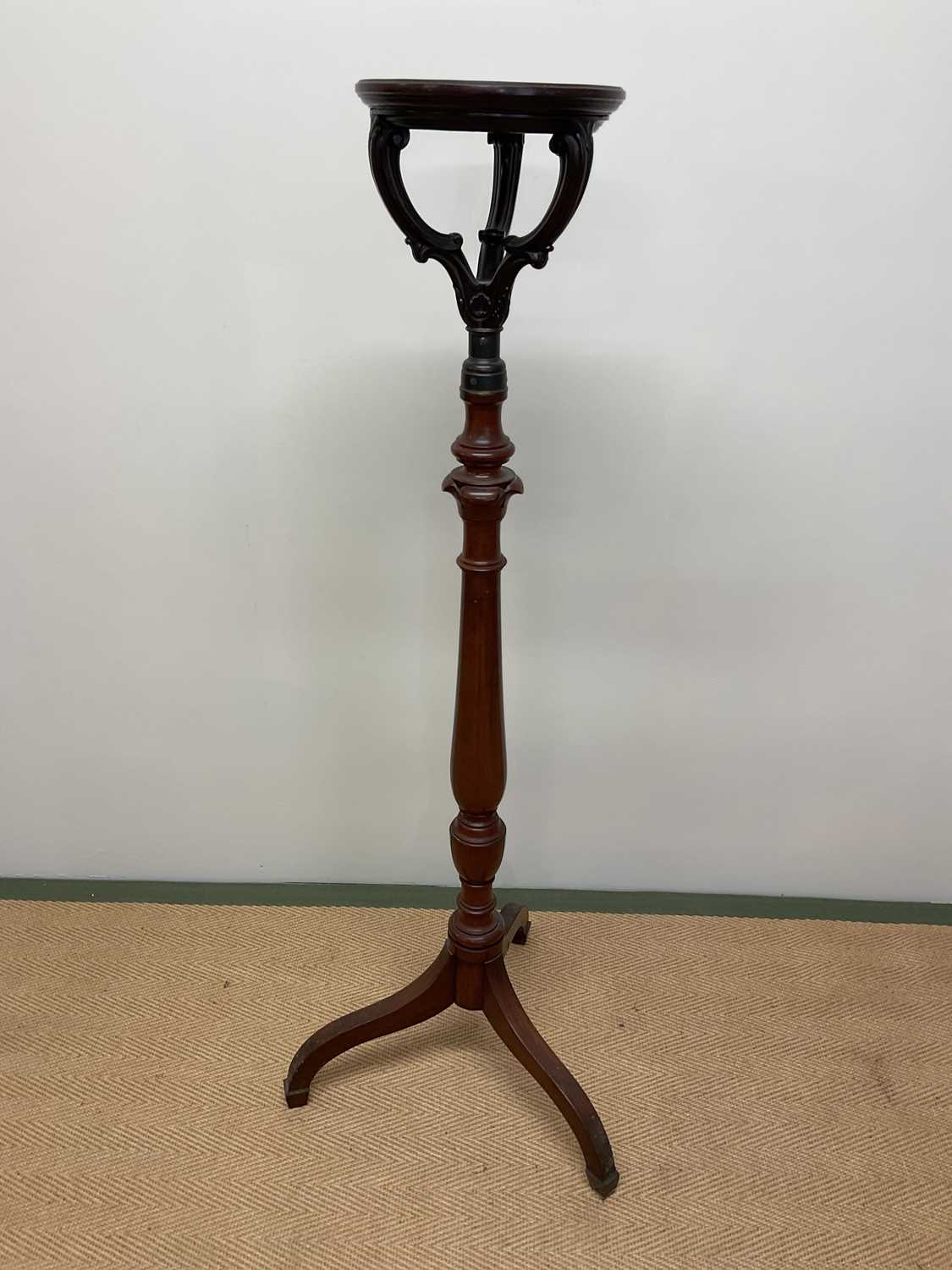 Lot 522 - A mahogany torchere stand with brass collar