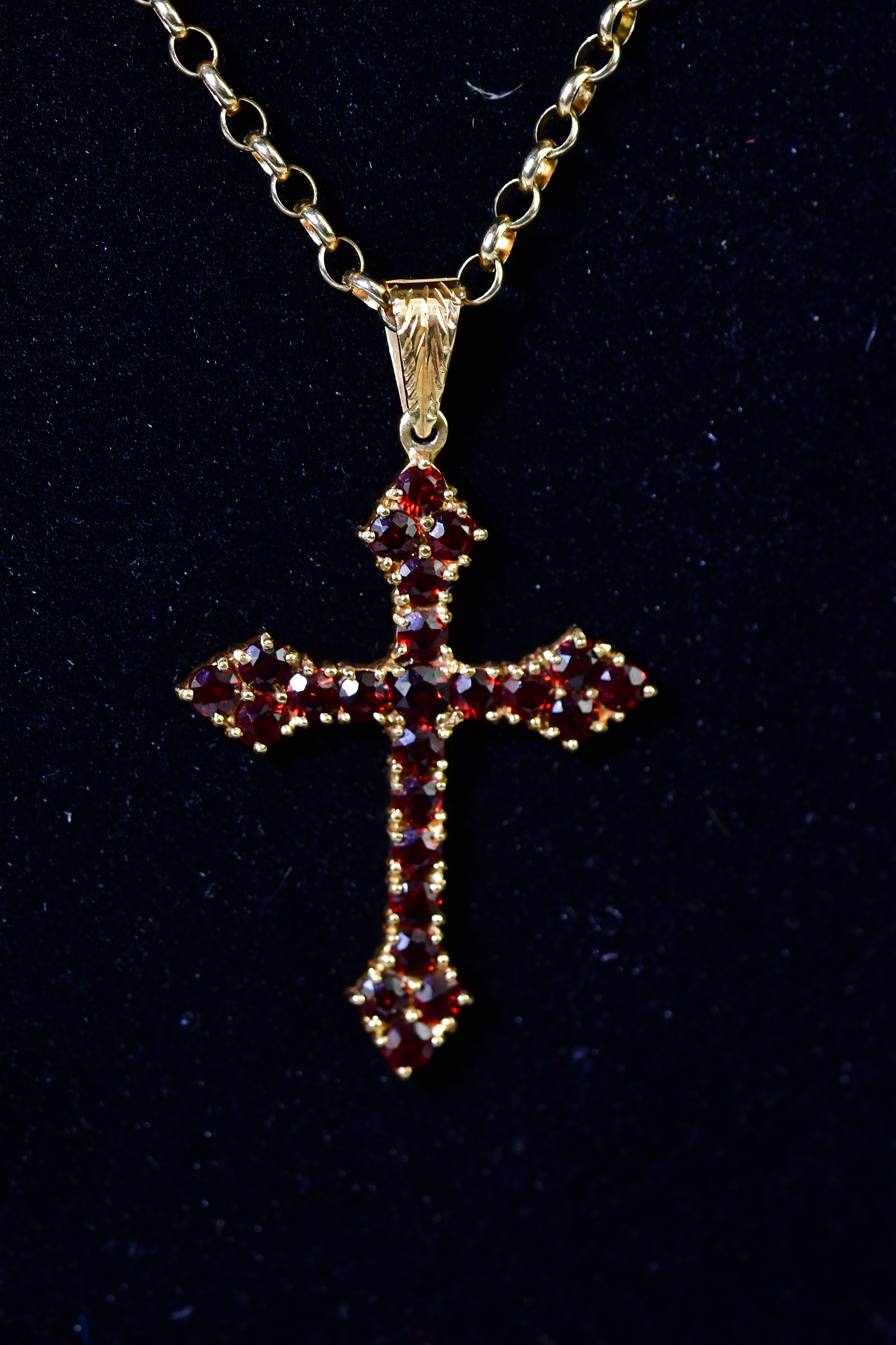 Lot 25 - An Italian yellow metal garnet set crucifx,