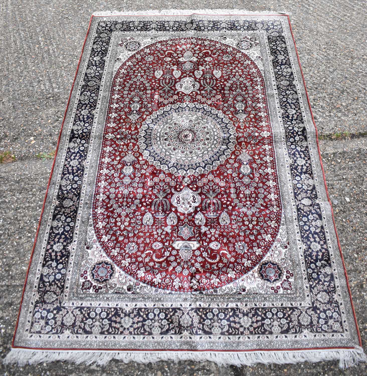 Lot 142 - A hand knotted woollen red ground carpet