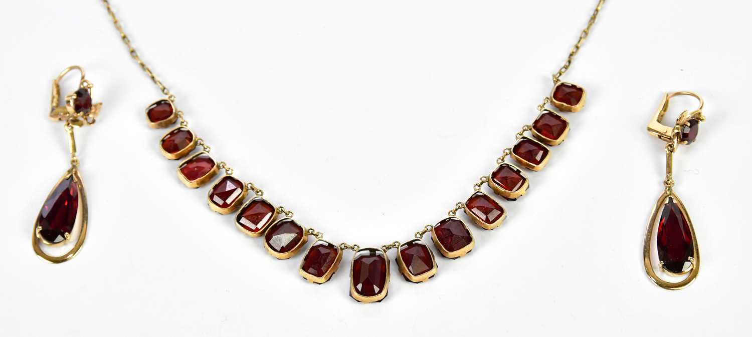 Lot 390 - A yellow metal graduated garnet set necklace,