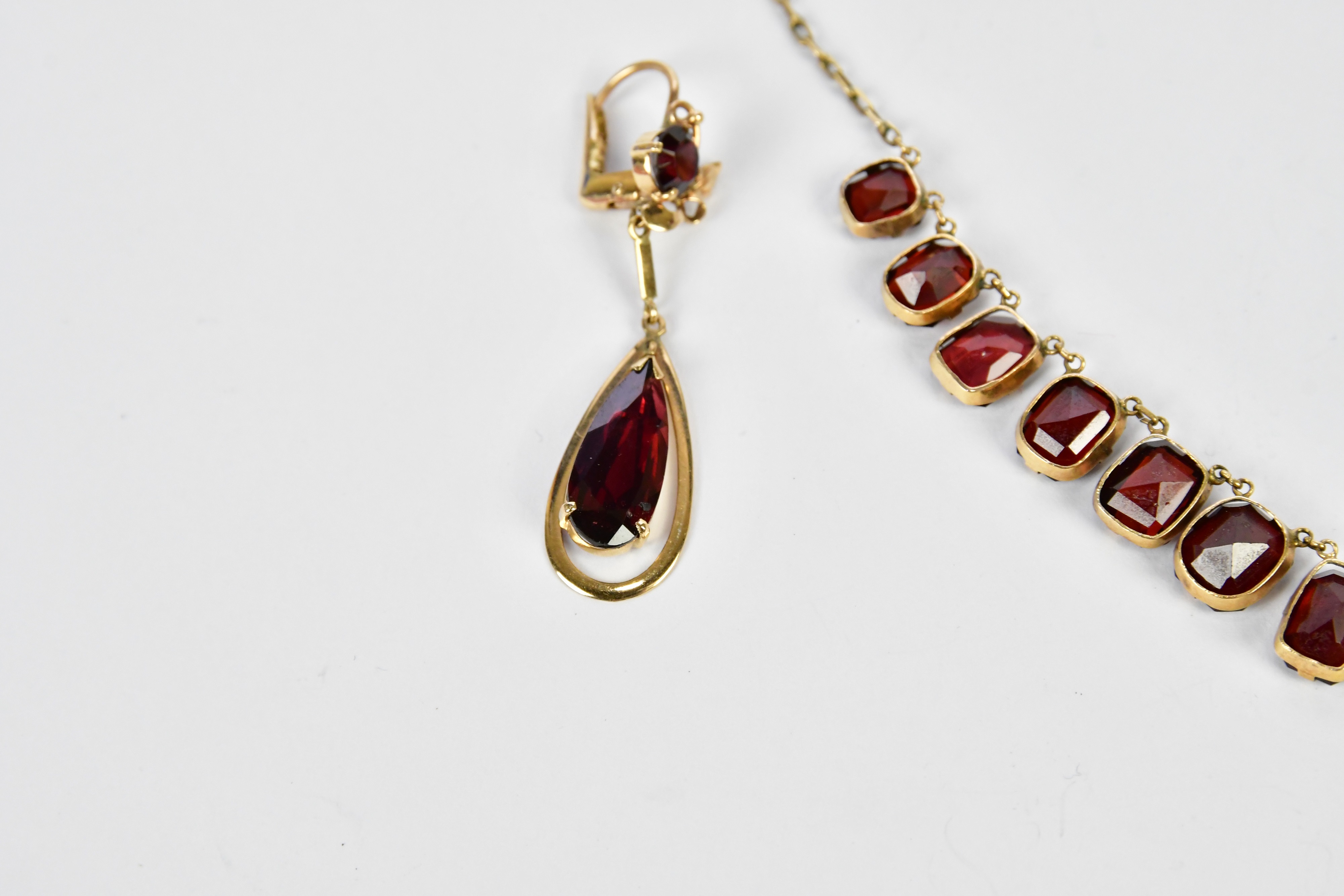Lot 390 - A yellow metal graduated garnet set necklace,