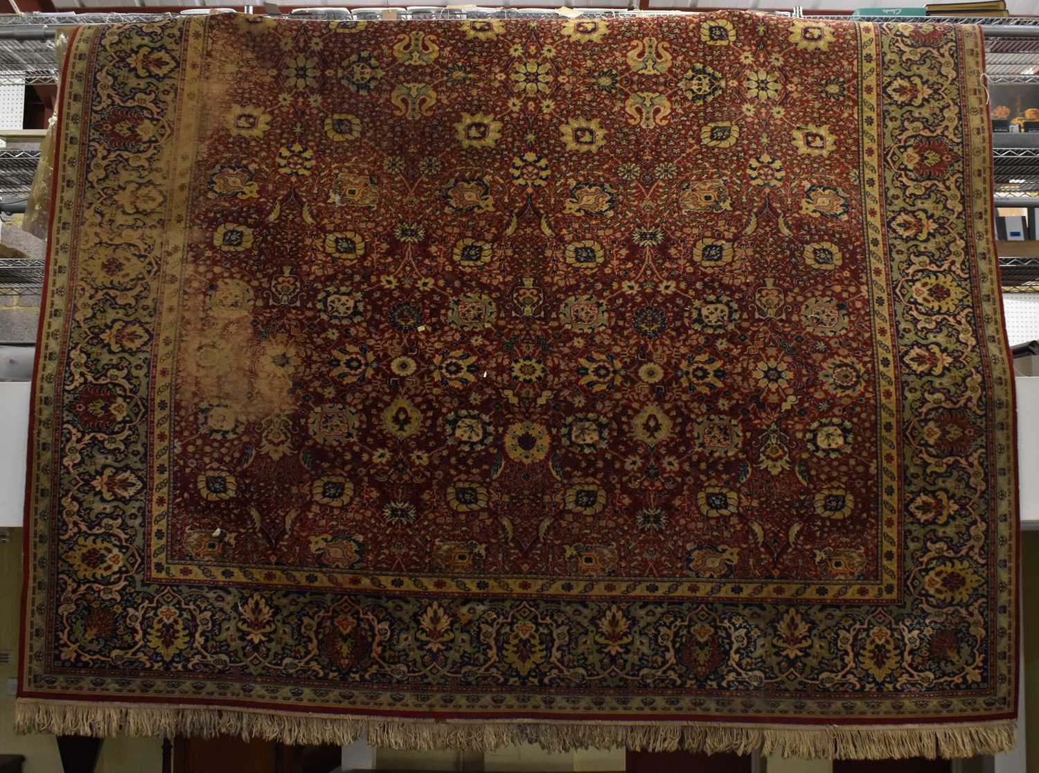 Lot 156 - A large machine made red ground carpet