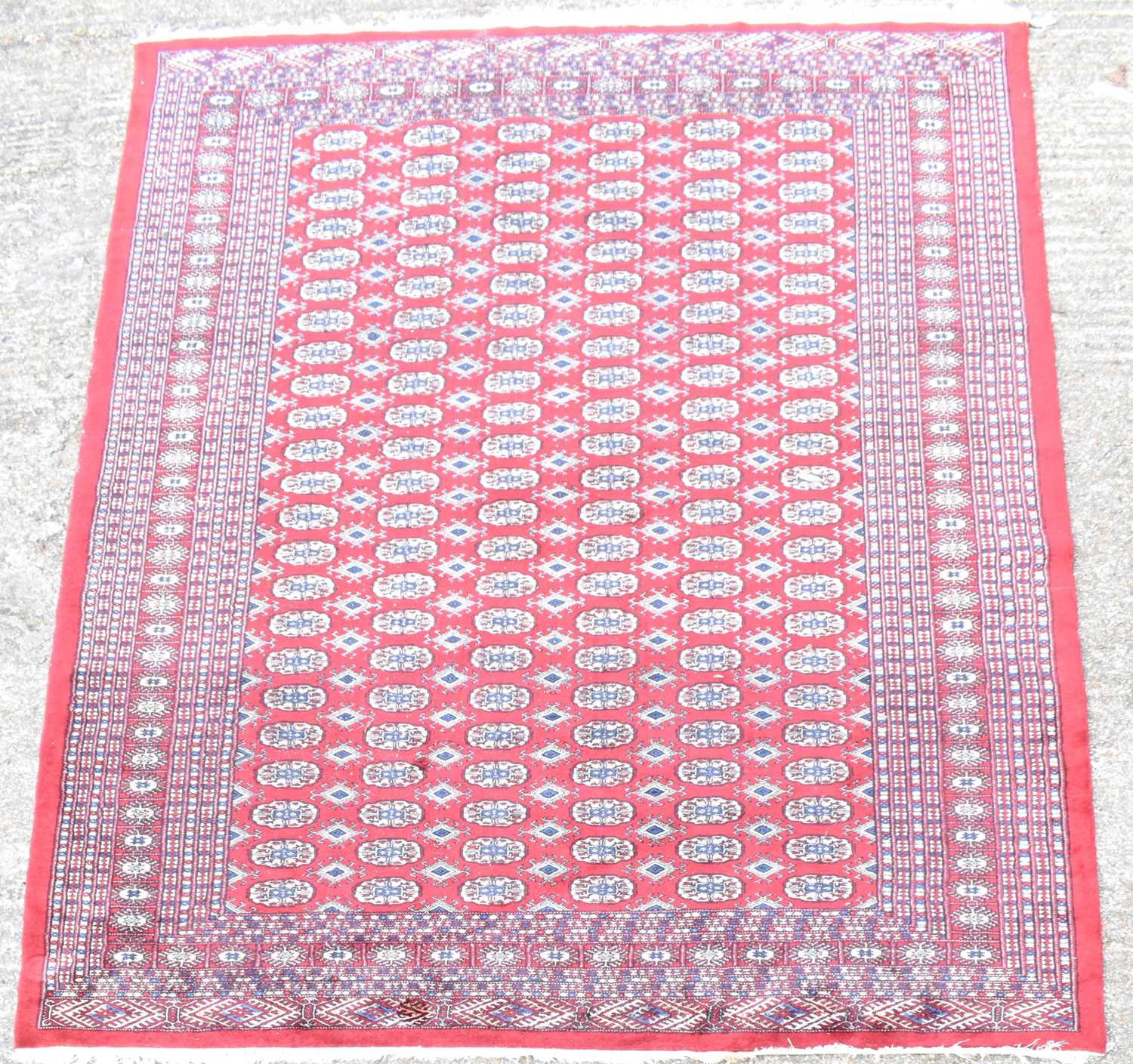 Lot 104 - A large Persian red ground carpet with