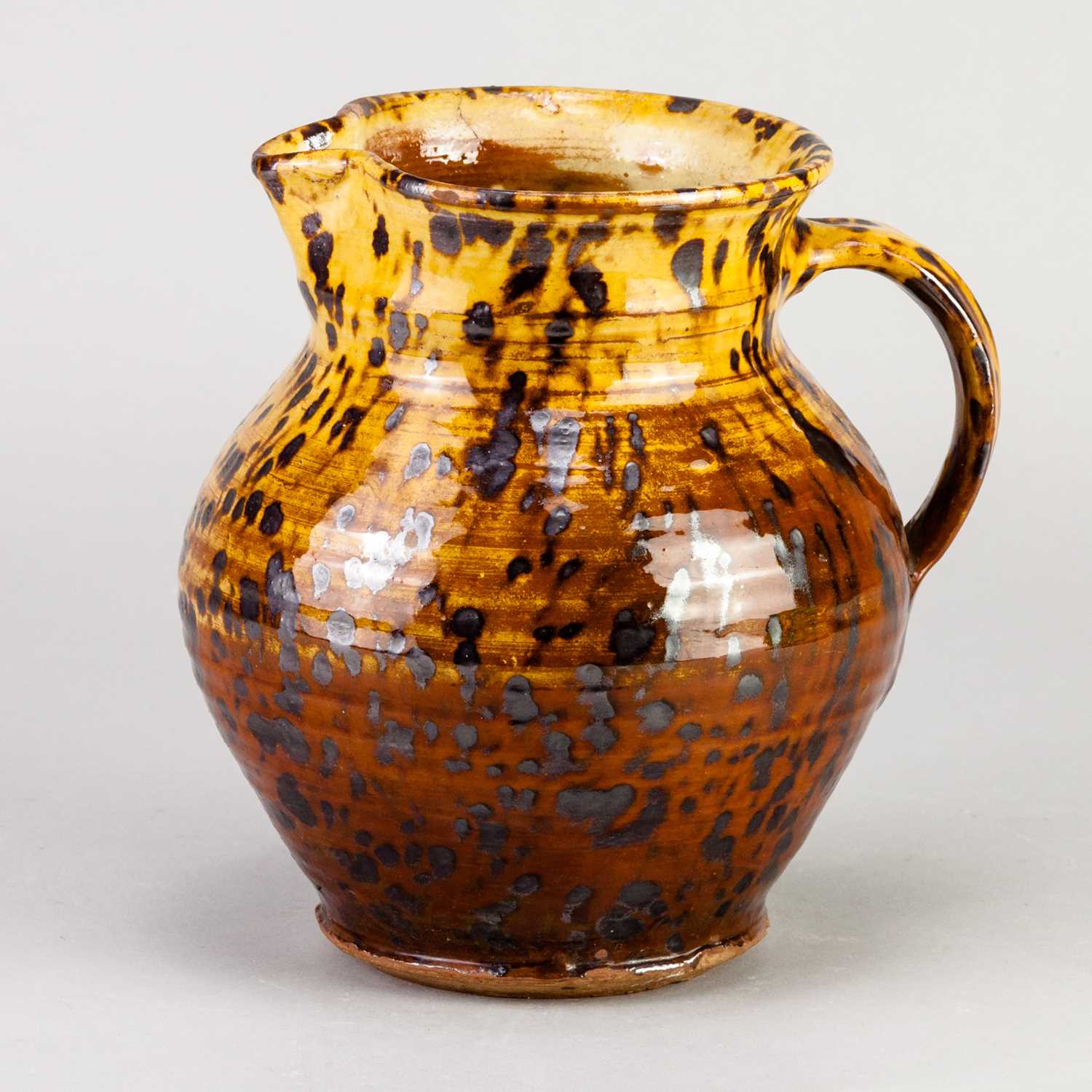 Lot 476 - Winchcombe Pottery; a slipware jug partially