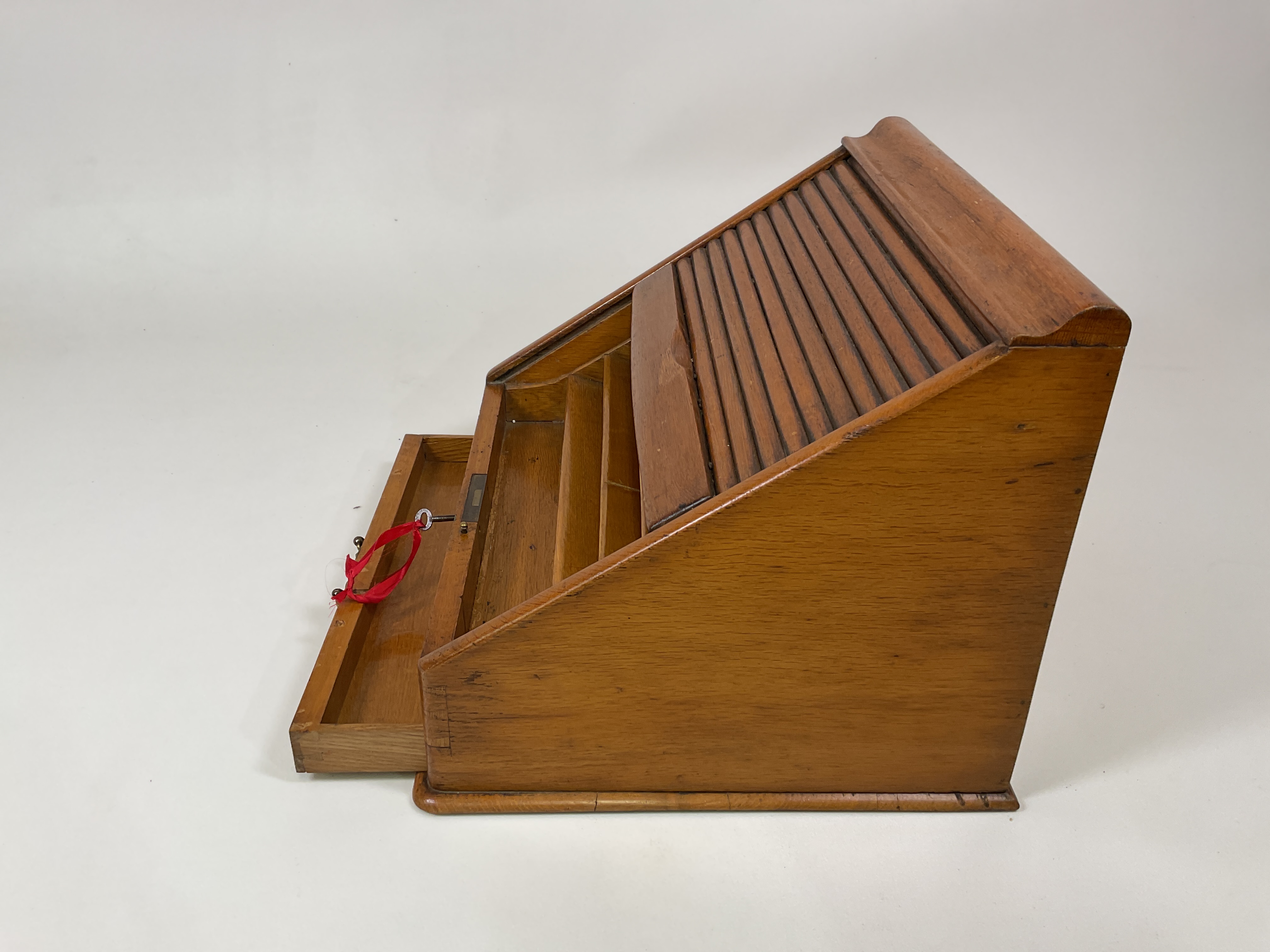 Lot 18 - A tambour front light oak desk tidy with
