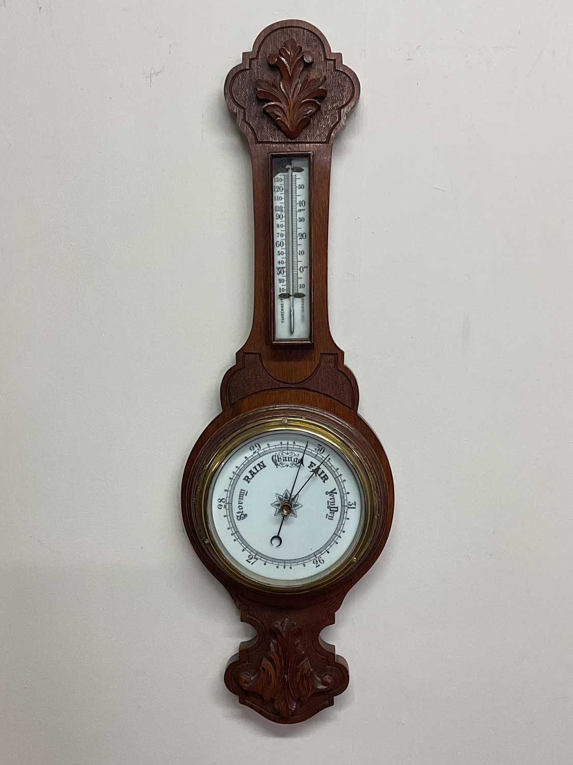 Lot 429 - A carved oak barometer with porcelain dial