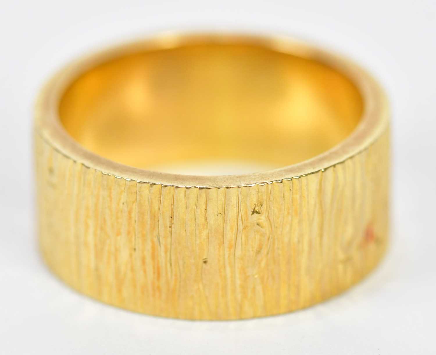 Lot 83 - An 18ct yellow gold textured wedding band,