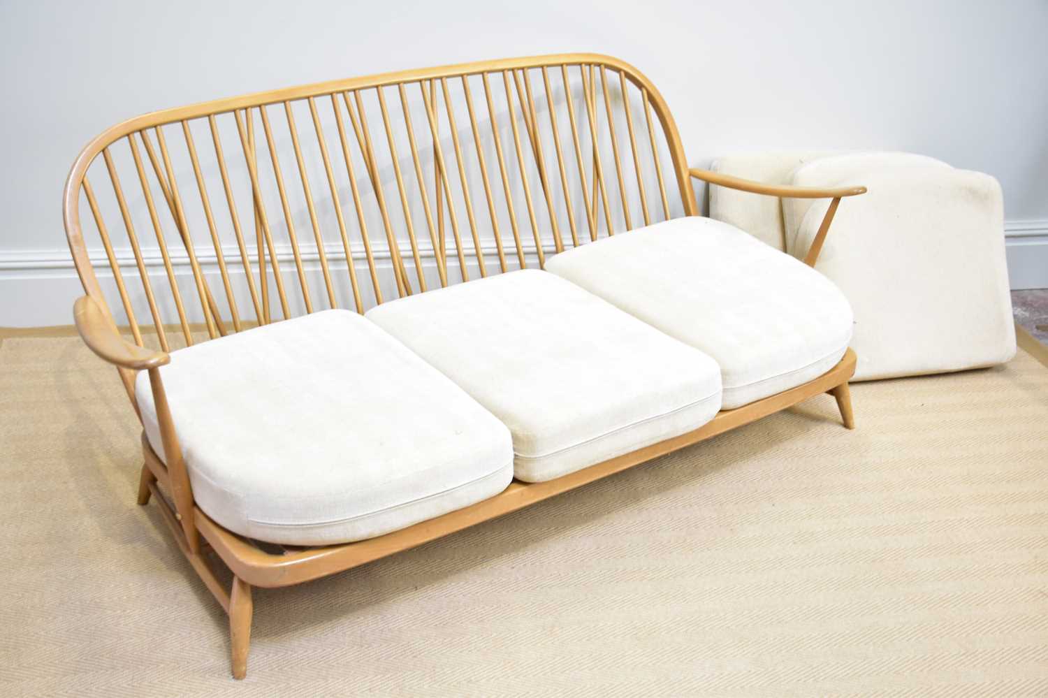 Lot 1151 - ERCOL; a light elm three seater spindle
