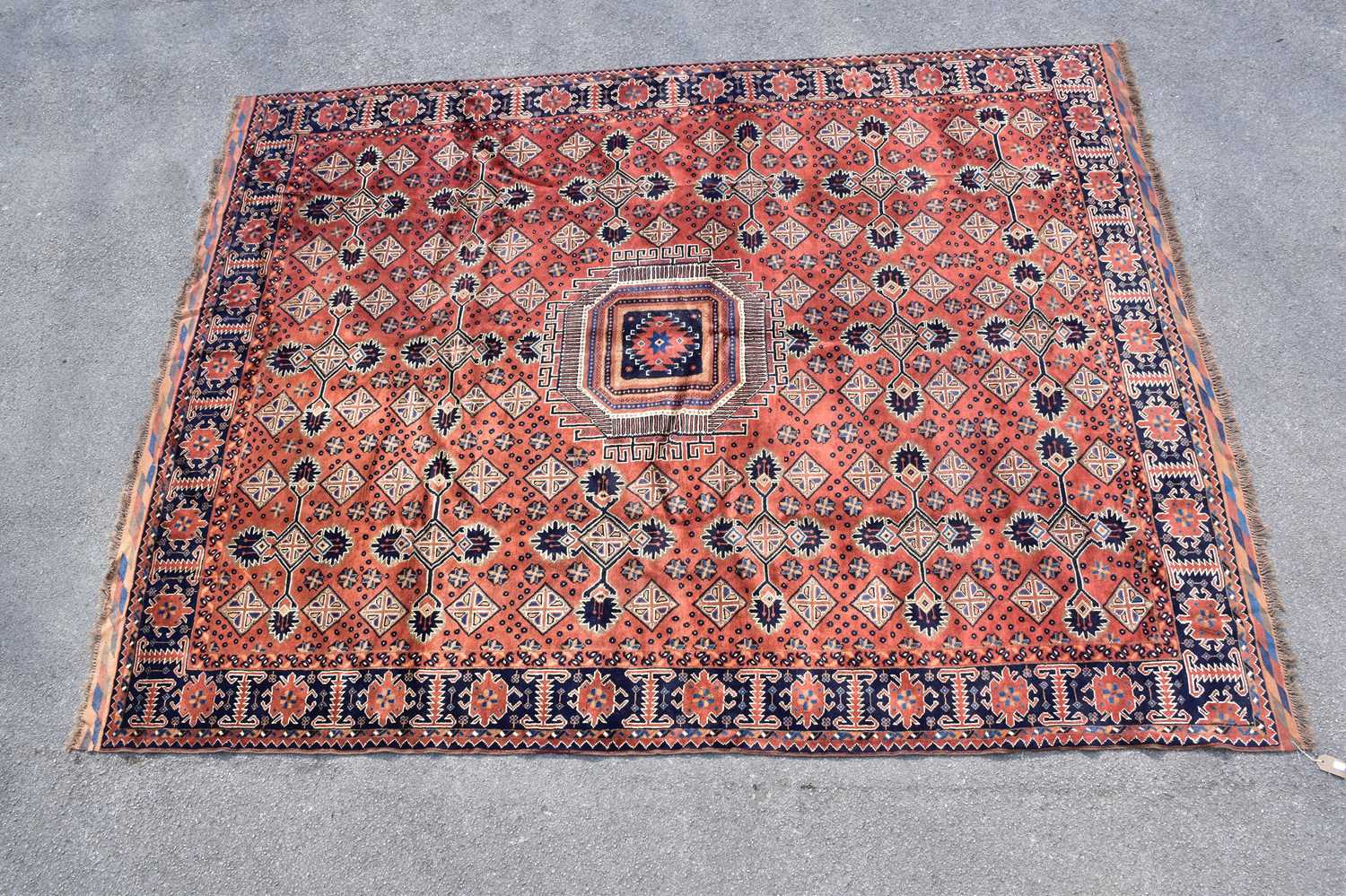 Lot 437 - An orange ground wool carpet with central