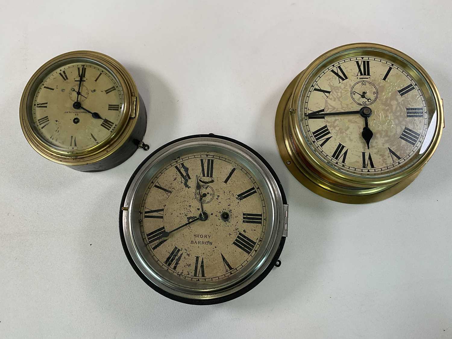 Lot 526 - Three brass cased wall clocks, all with