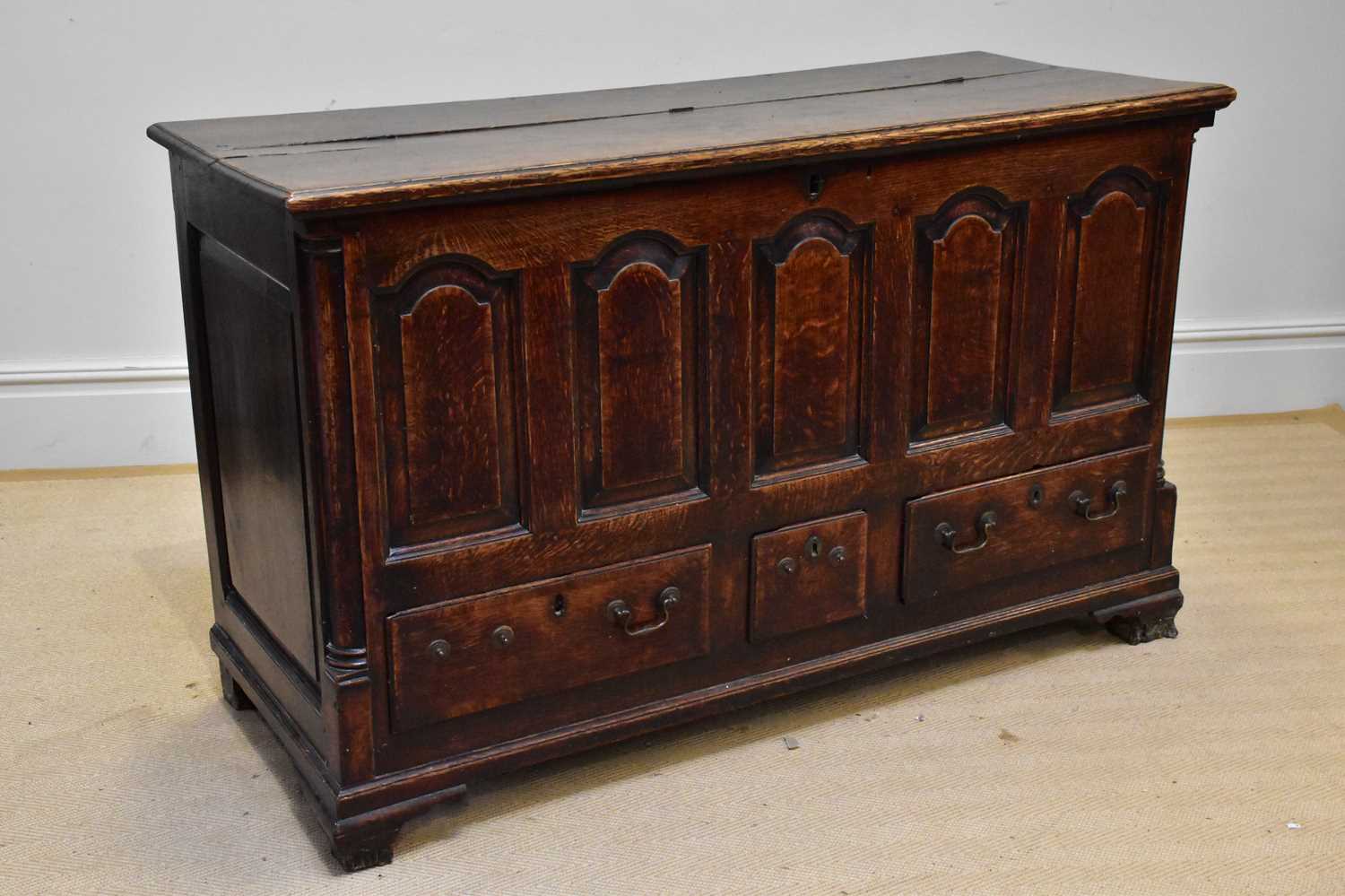 Lot 1386 - An 18th century oak coffer with hinged lid