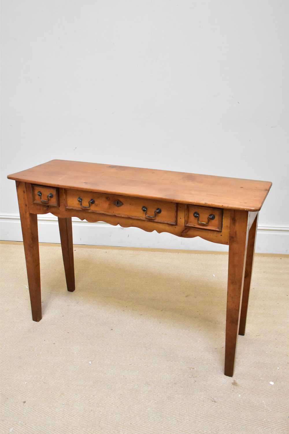 Lot 1301 - A Continental pine console table with three