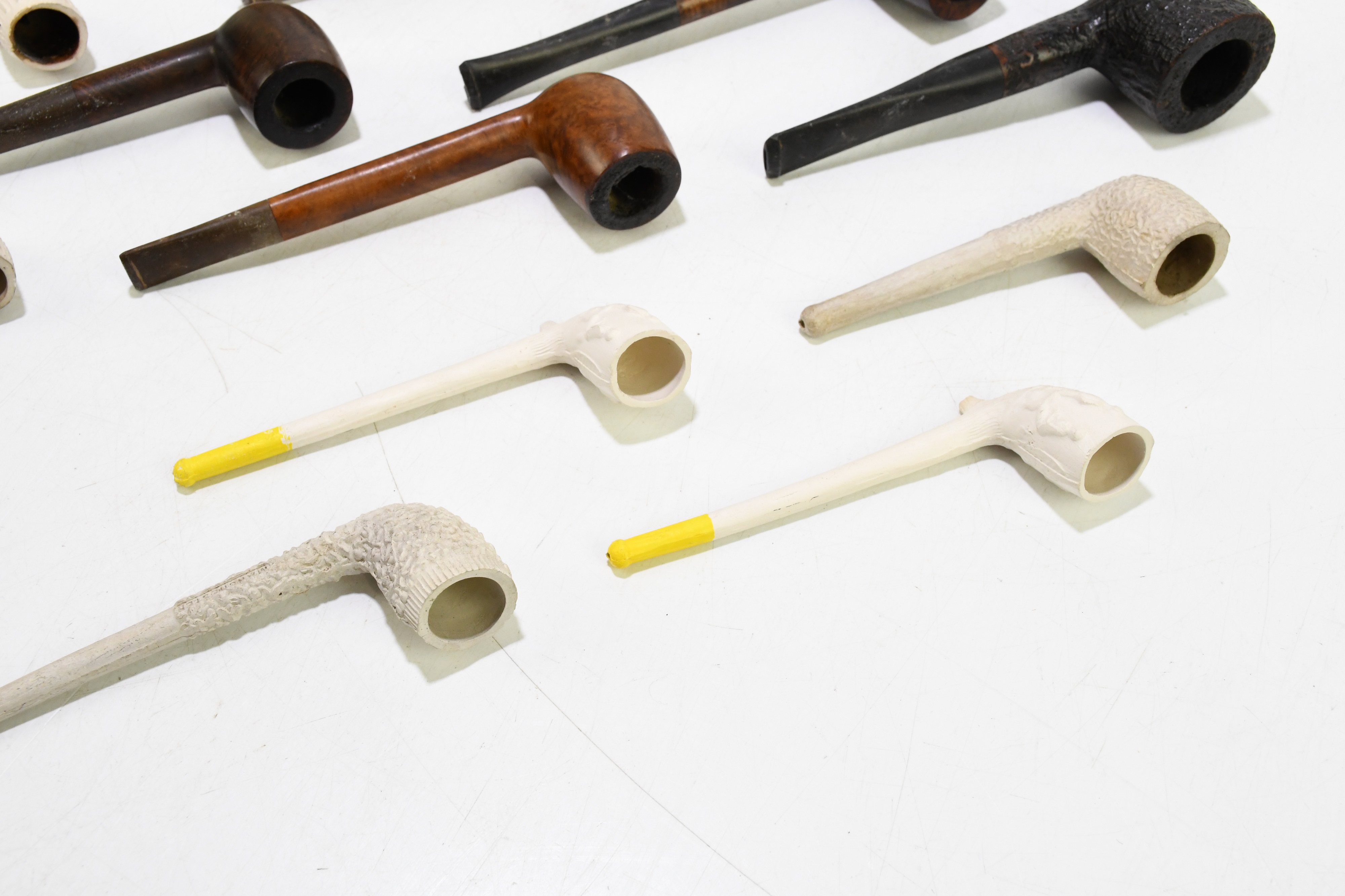 Lot 142 - A small collection of wood and clay pipes,